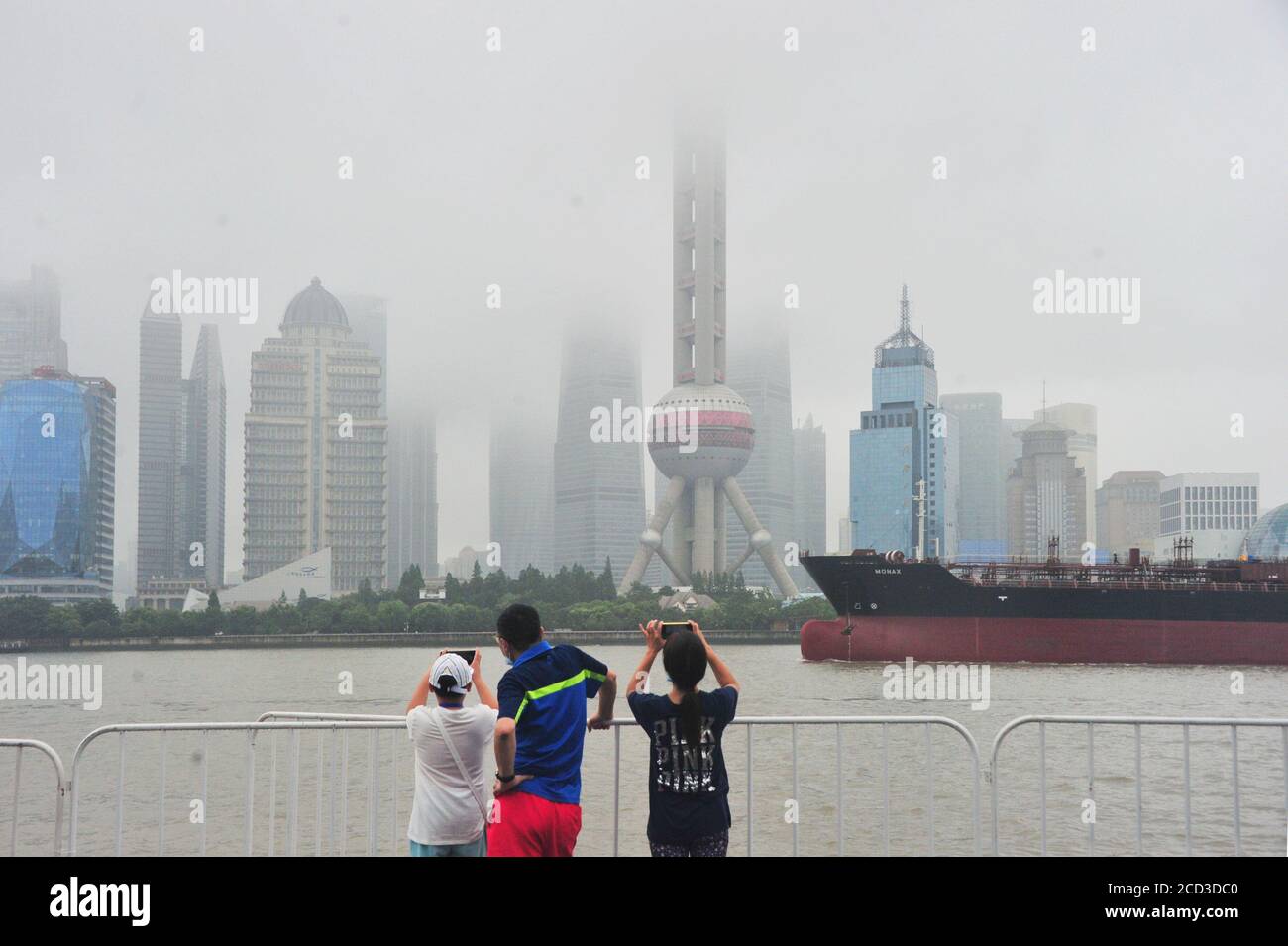 People take pictures of the Pearl Tower in fog and mist in Shanghai ...