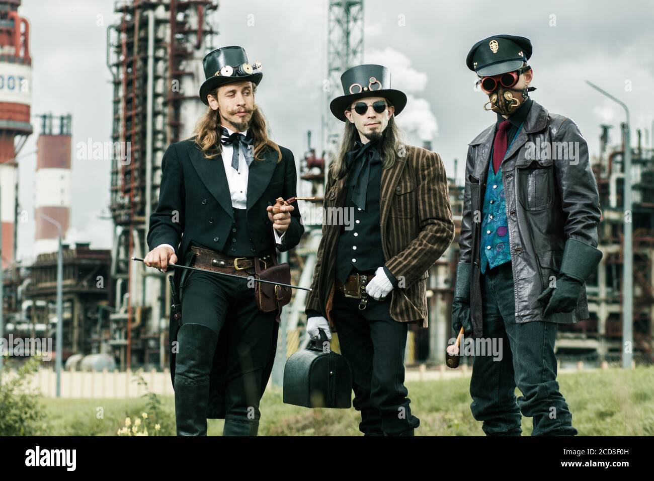 Three mans in steampunk style standing against the industrial ...