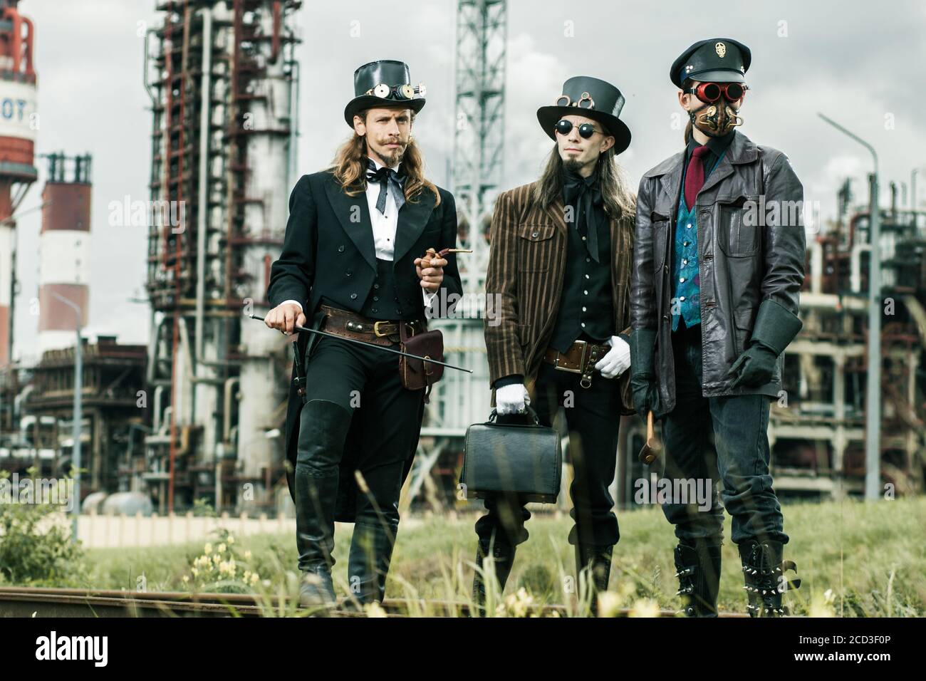 Three mans in steampunk style standing against the industrial ...