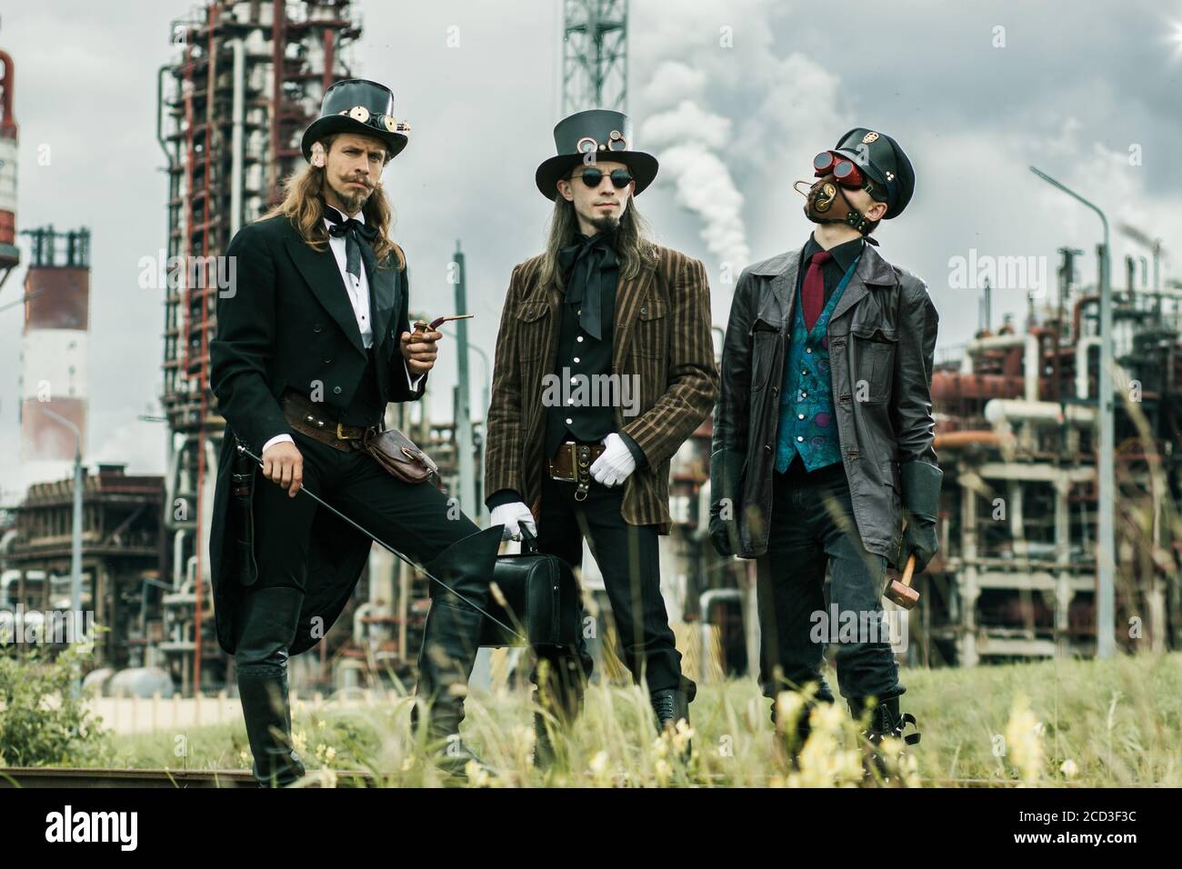 Three mans in steampunk style standing against the industrial ...