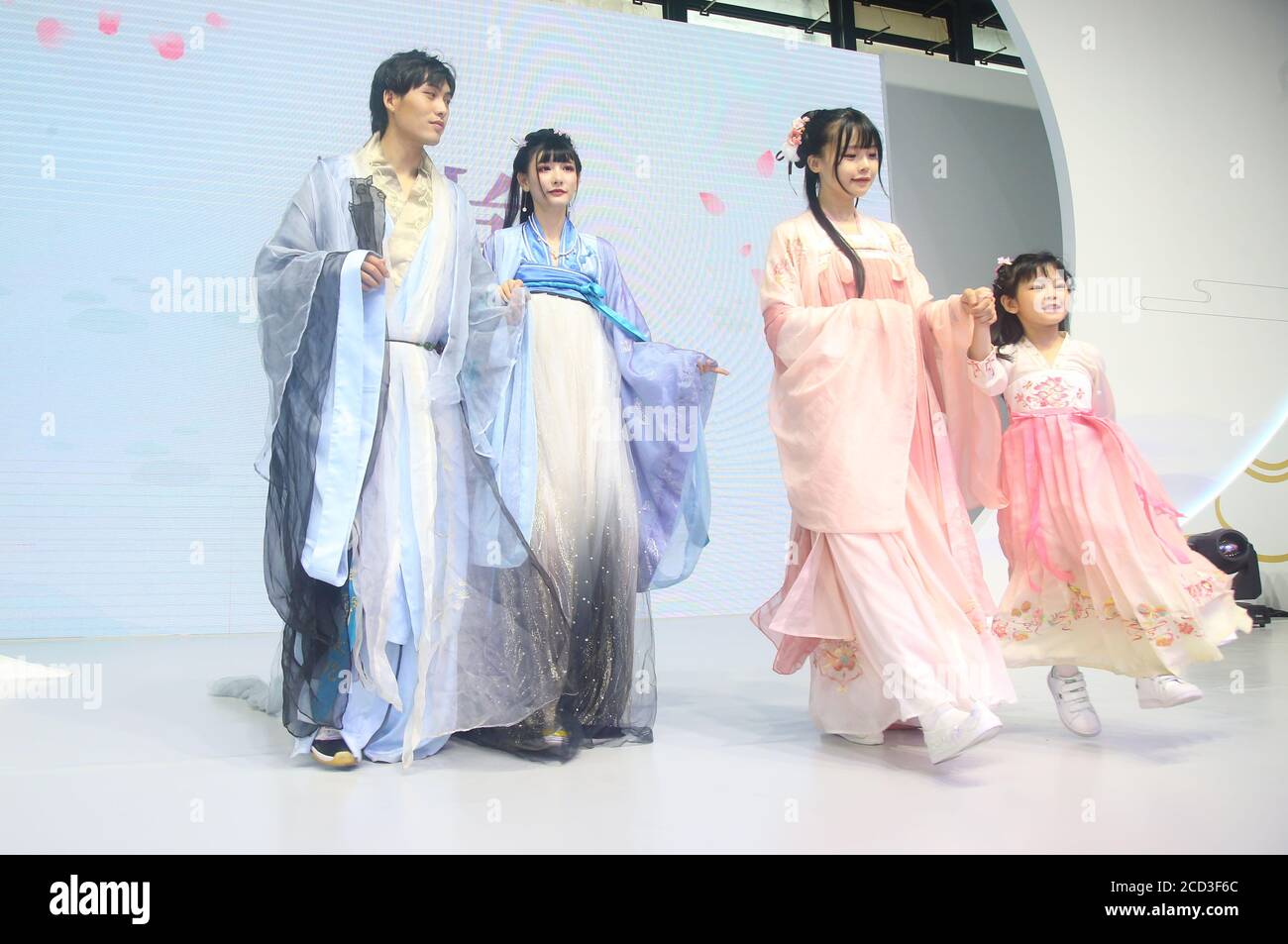 Beautiful cosplayers are seen posing and performing in clothes shown in ...