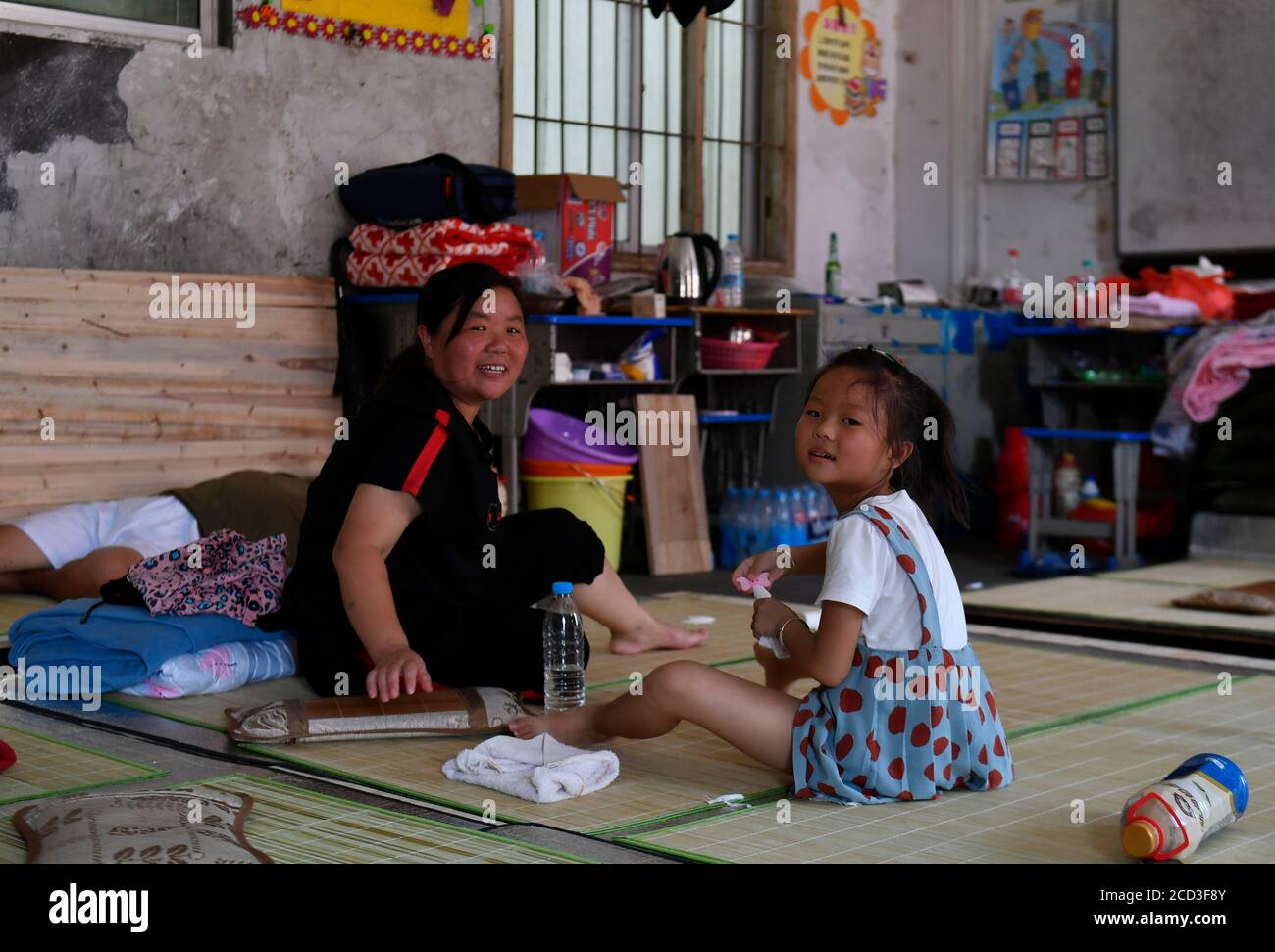 Villagers resettled at the temporary shelter site rest at the Wuyi Zhongxin School in Shangrao ...
