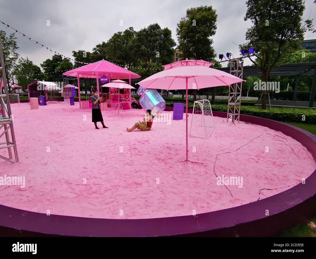 Customers play around the pink beach, which is composed of pink sands ...