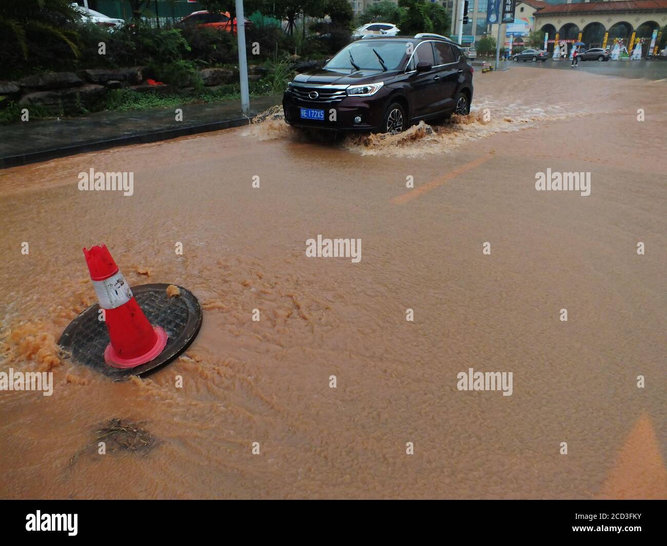 A manhole cover is pushed aside by rising underground water level ...
