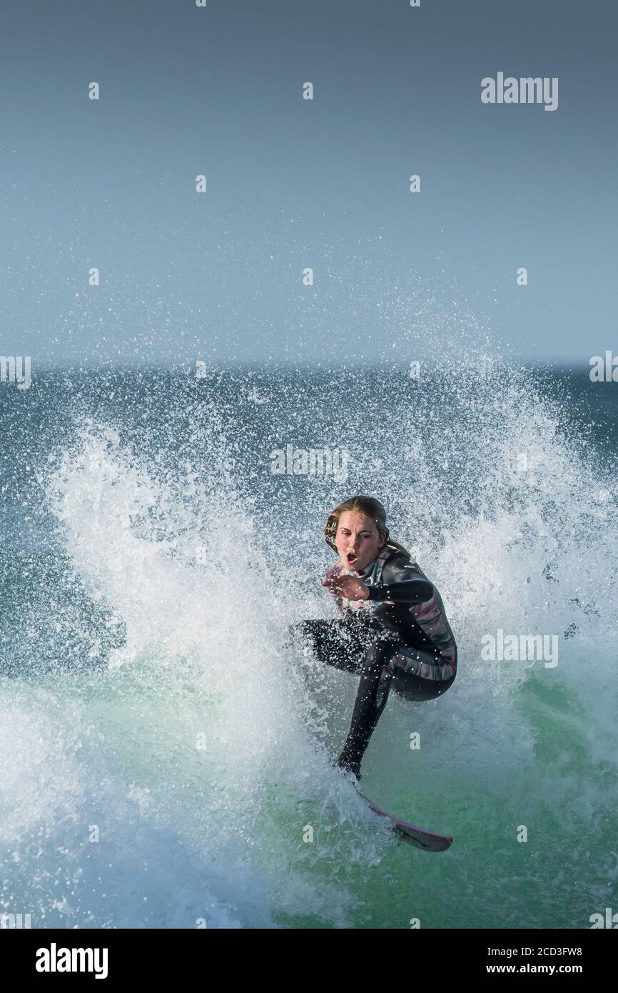 A teenage female surfer surfing at Fistral in Newquay in Cornwall Stock ...