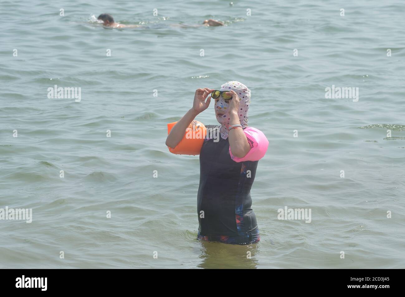 People enjoy beach and sunshine with facekini on, a mask designed for ...