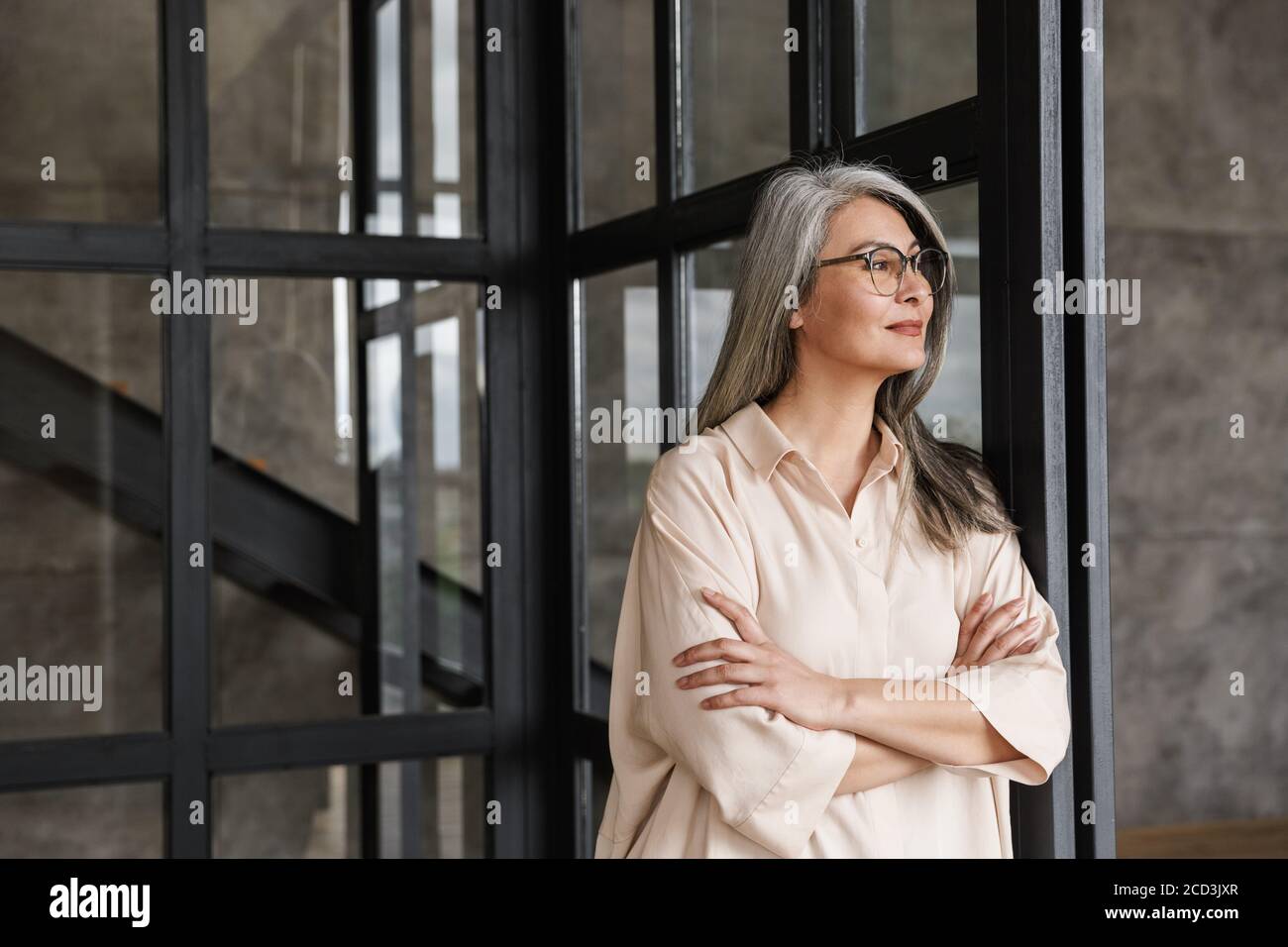 Image of mature concentrated beautiful woman indoors at home standing ...