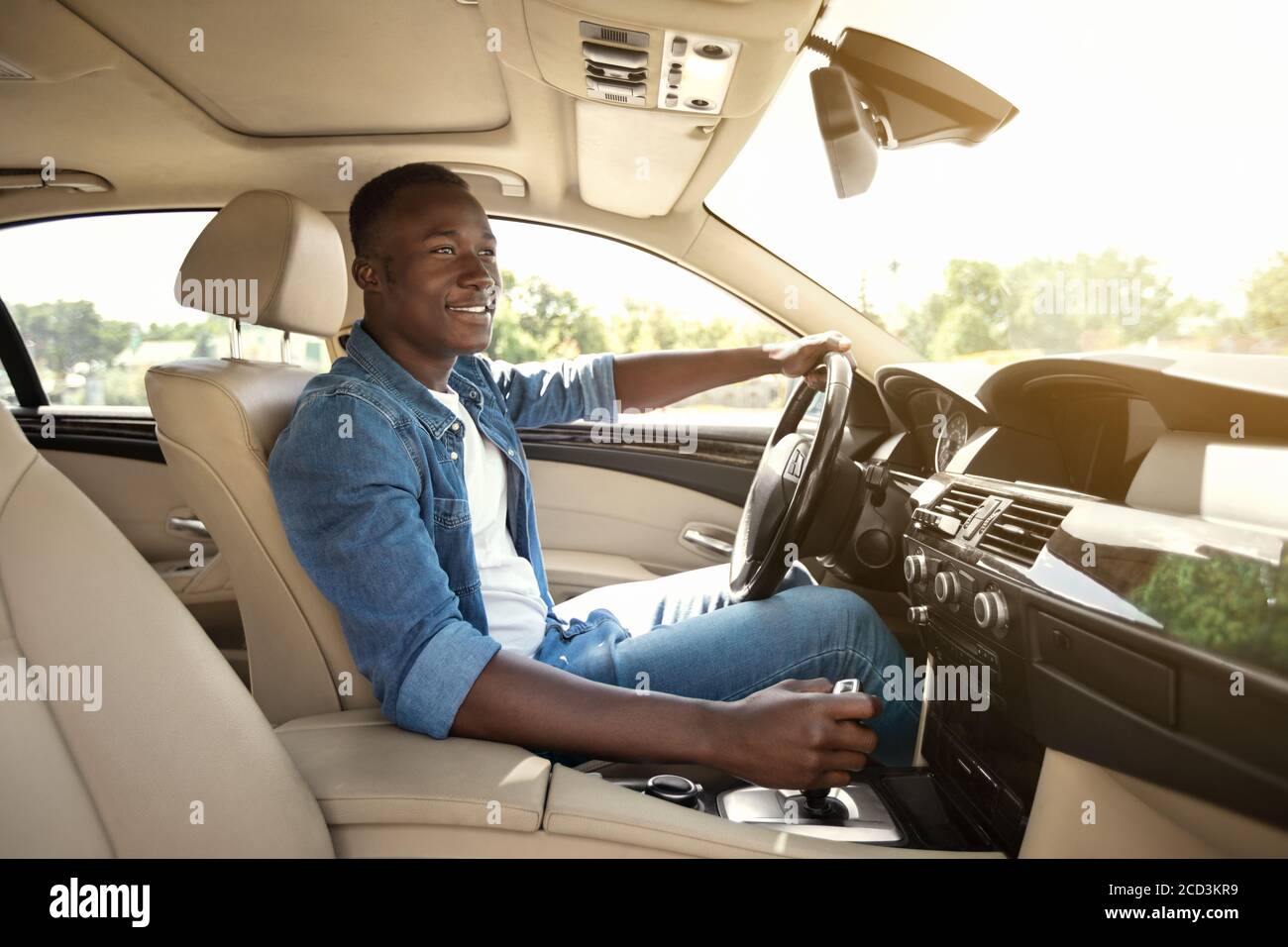 Happy black guy driving car, inside shot Stock Photo - Alamy