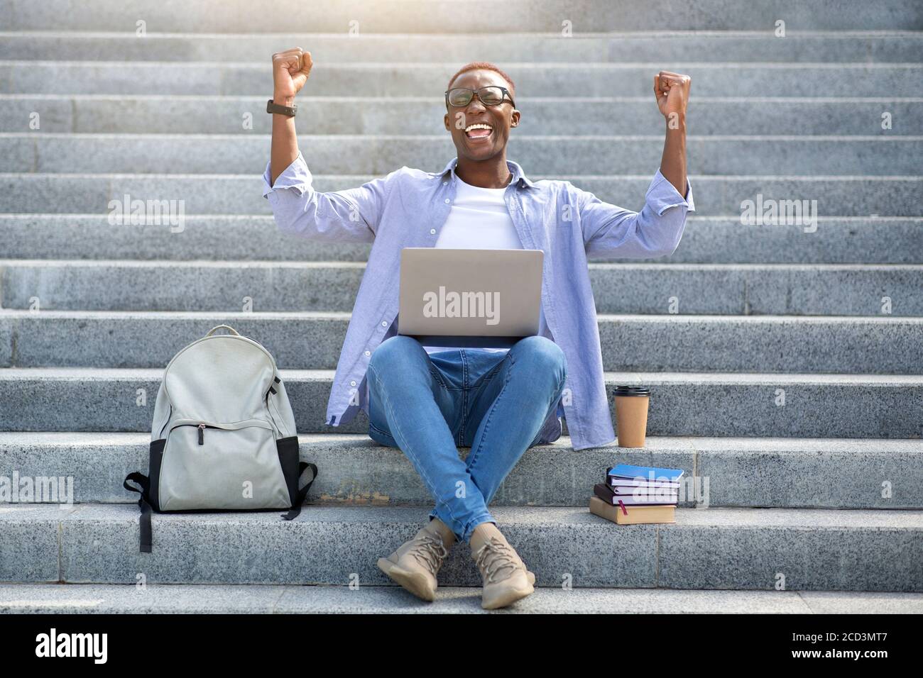 Excited black man celebrating his success in front of laptop computer ...