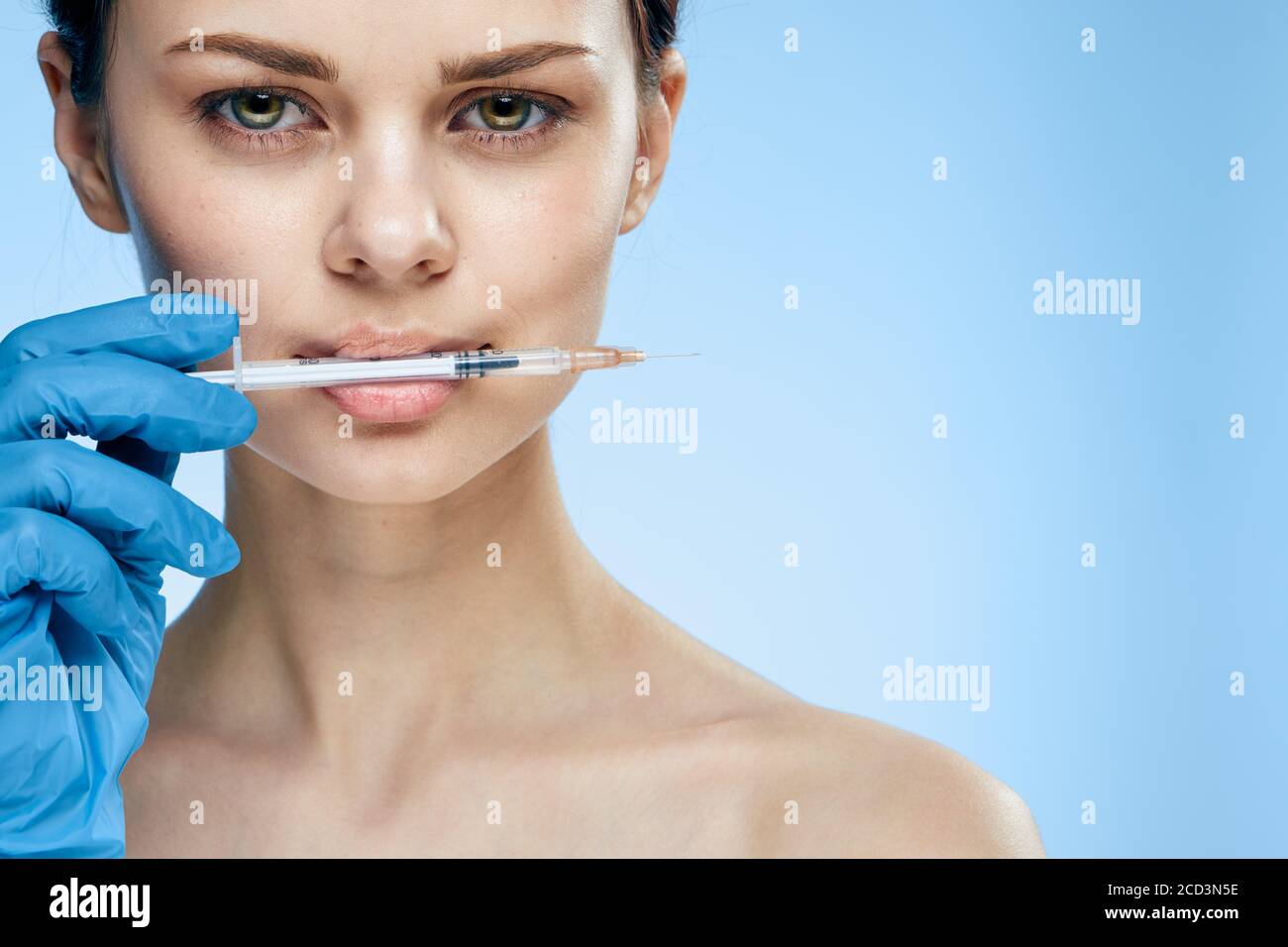 Woman in blue gloves with syringe in hand with botox injection ...