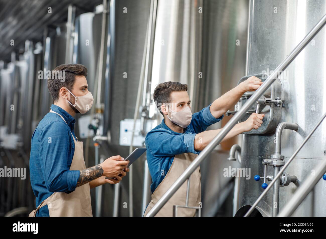 Beer production process. Two guys work with equipment Stock Photo - Alamy