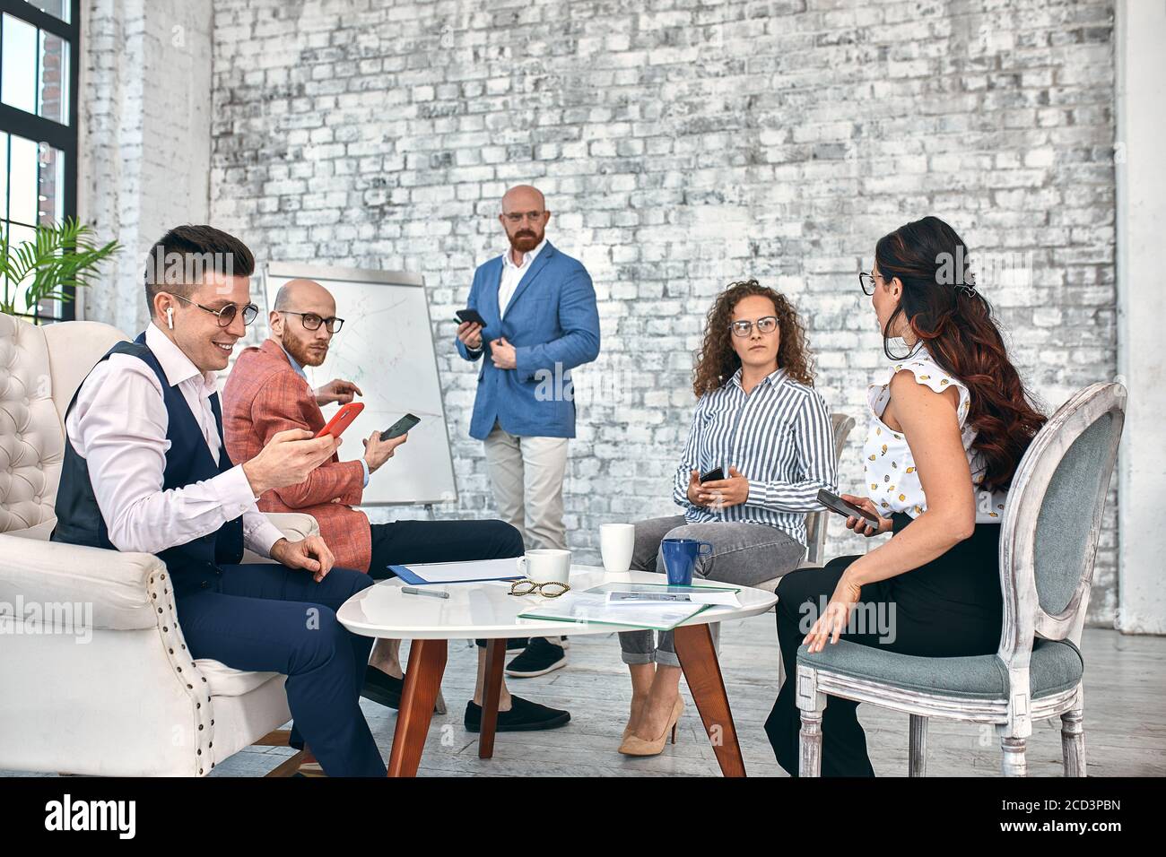 Beautiful business people are using gadgets, talking and smiling during ...