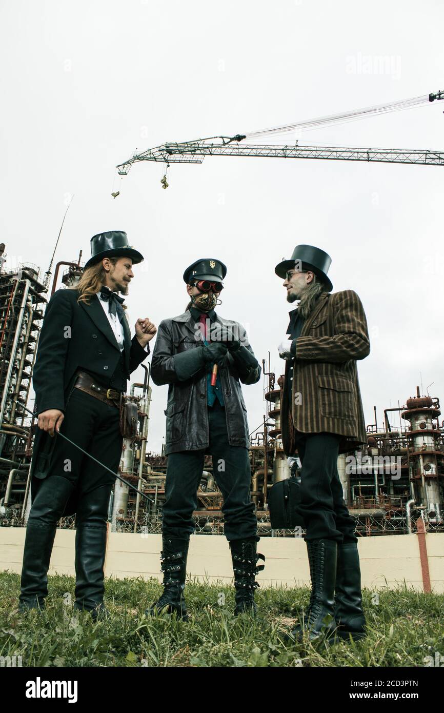 Three mans in steampunk style discuss standing against the industrial ...