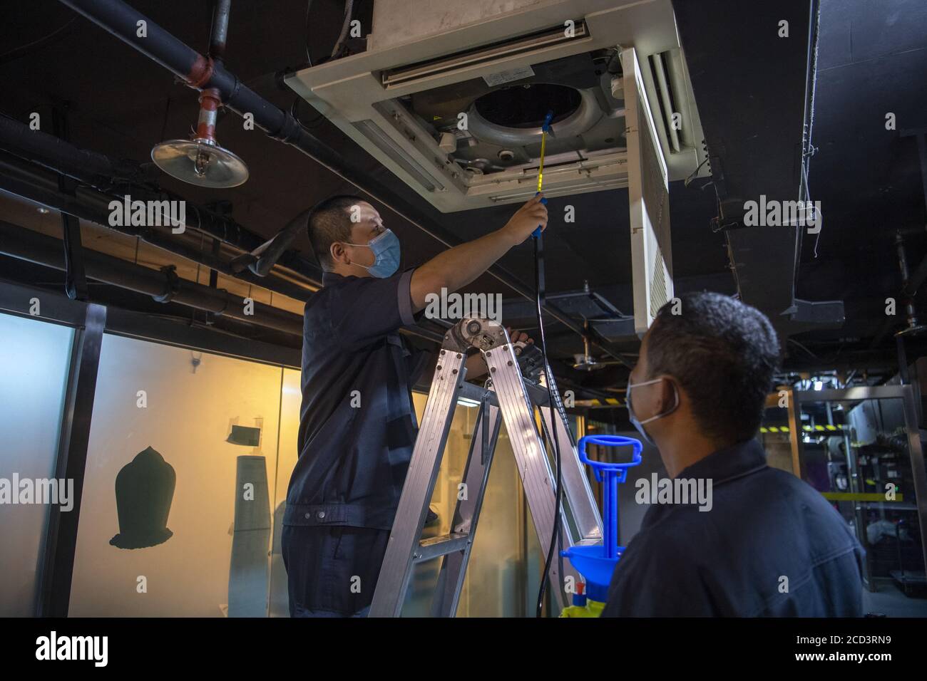 Staff check machines at a local cinema, preparing to show movies to the ...