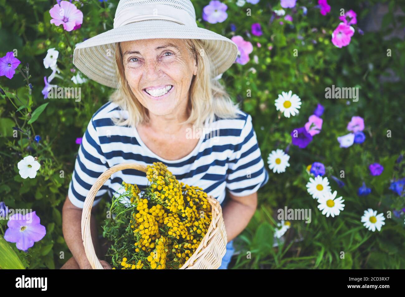 Happy smiling elderly senior woman having fun posing in summer garden ...