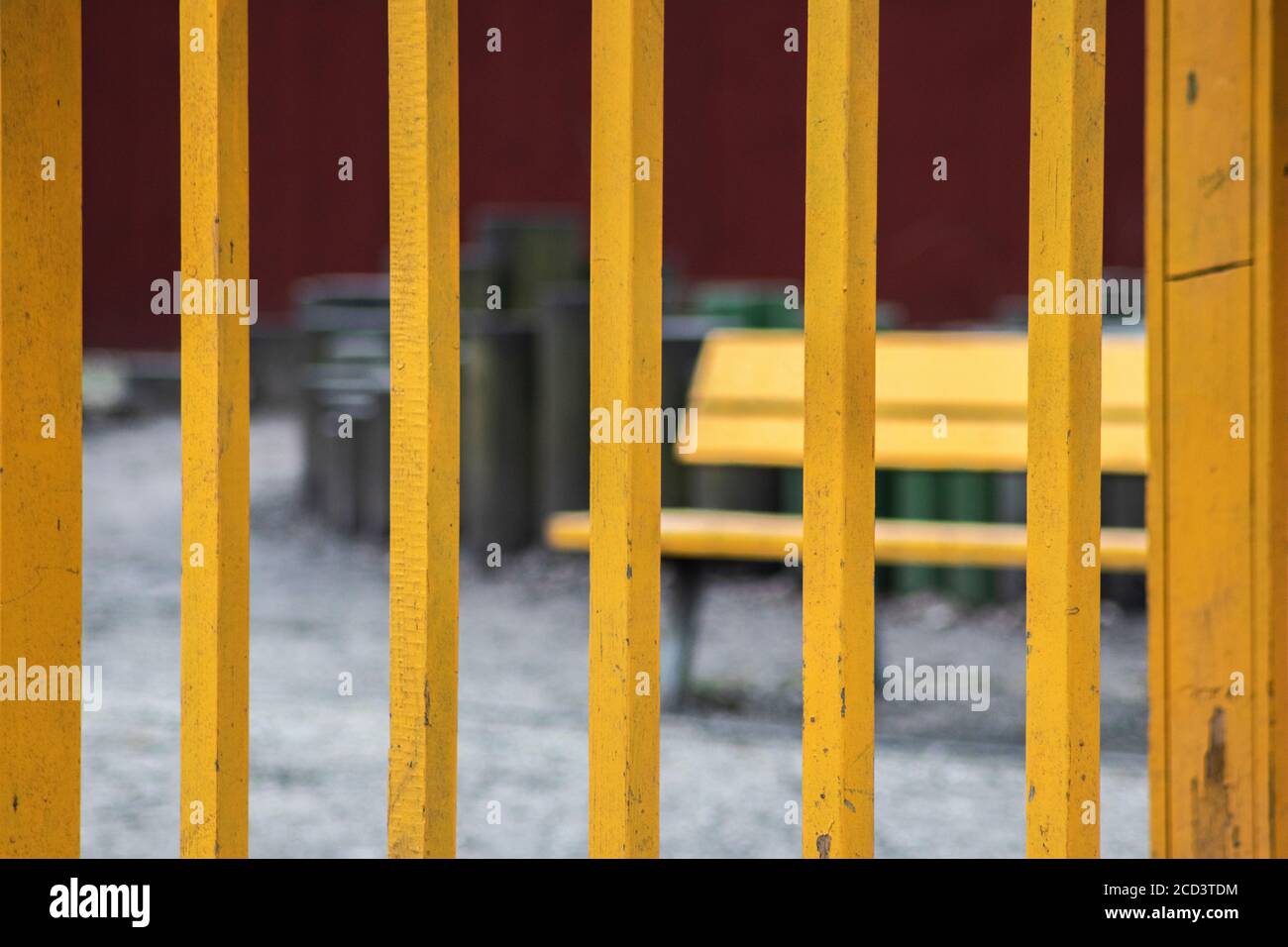 Yellow bench behind yellow fence Stock Photo - Alamy