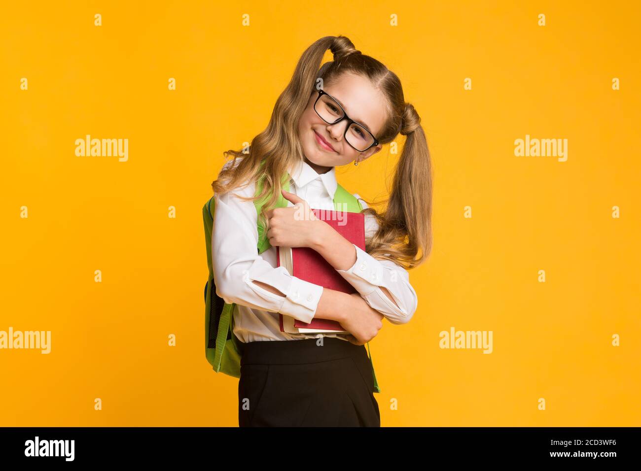 Cute School Girl Embracing Books Posing Standing In Studio Stock Photo ...