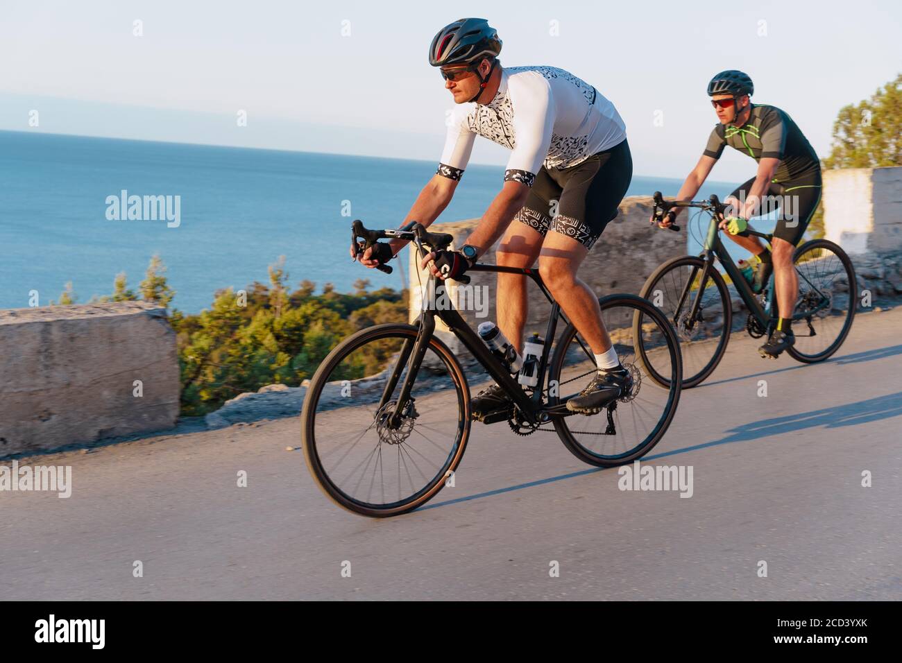 Two professional male cyclists riding their racing bicycles in the ...