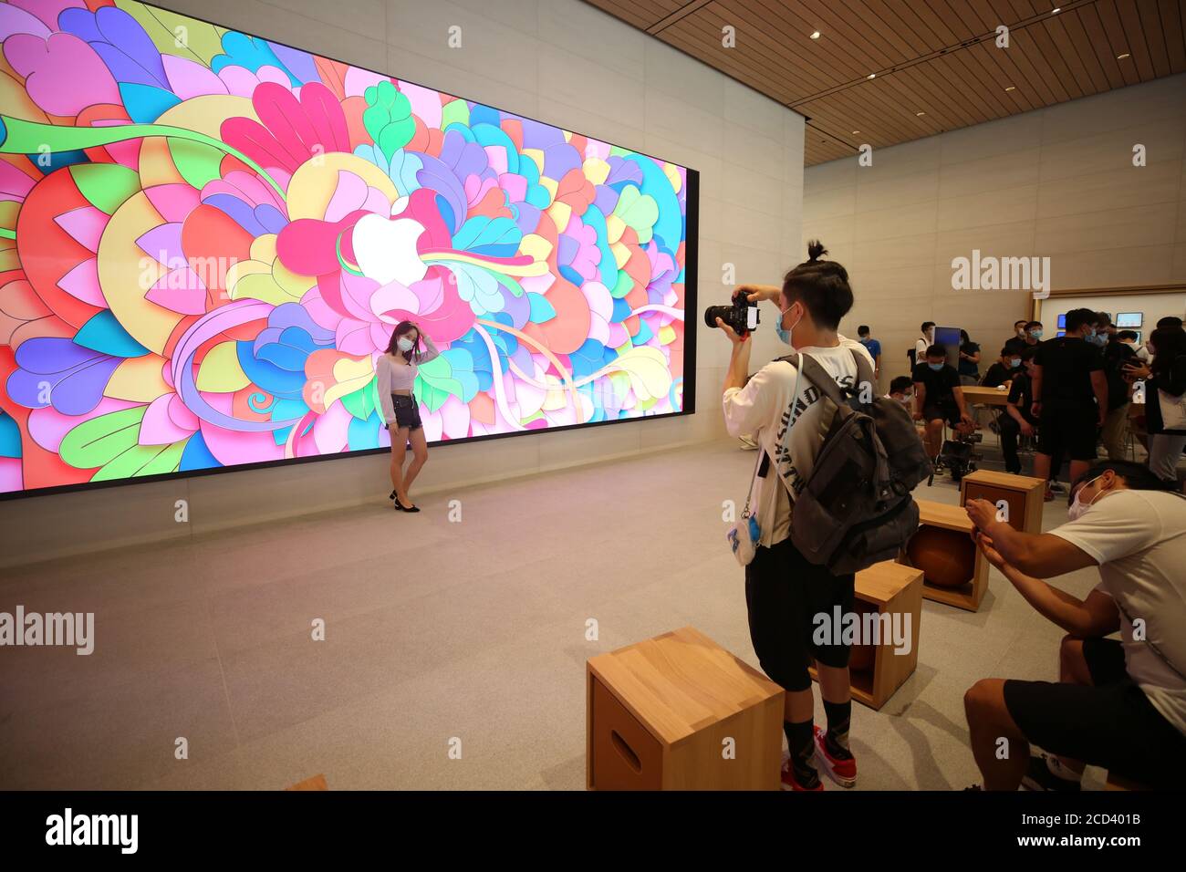 People take photos with Apple logo and screen inside the newly-opened ...