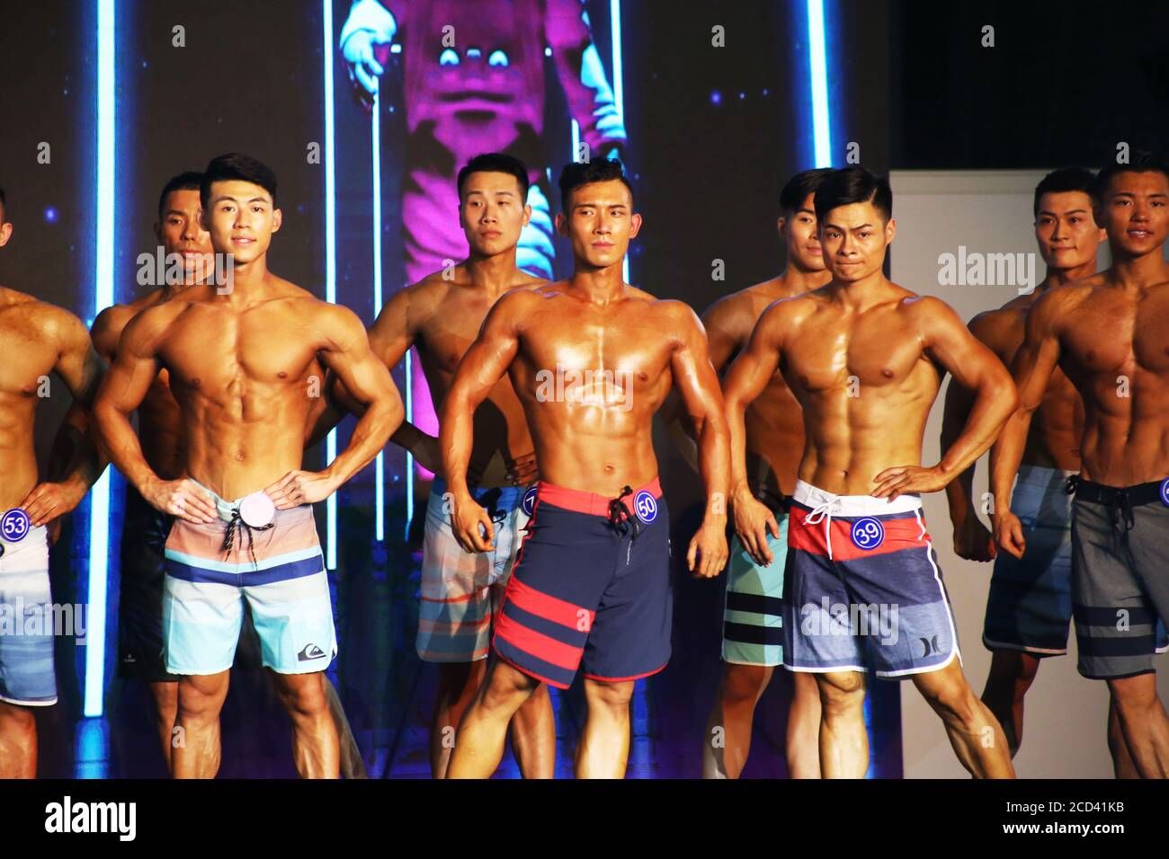 Male participants pose to show their muscle and body during a ...