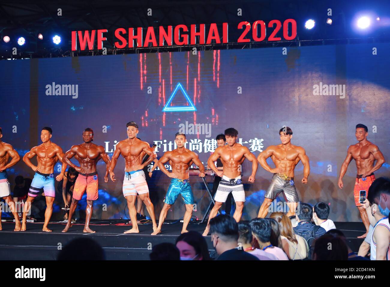 Male participants pose to show their muscle and body during a ...