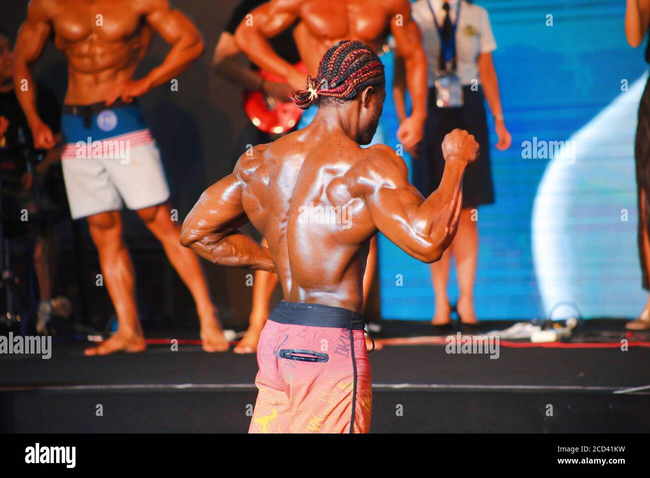 Male participants pose to show their muscle and body during a ...
