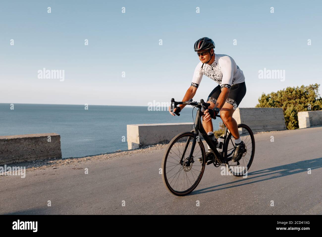 Cycling sport athlete man riding on coastal road Stock Photo - Alamy