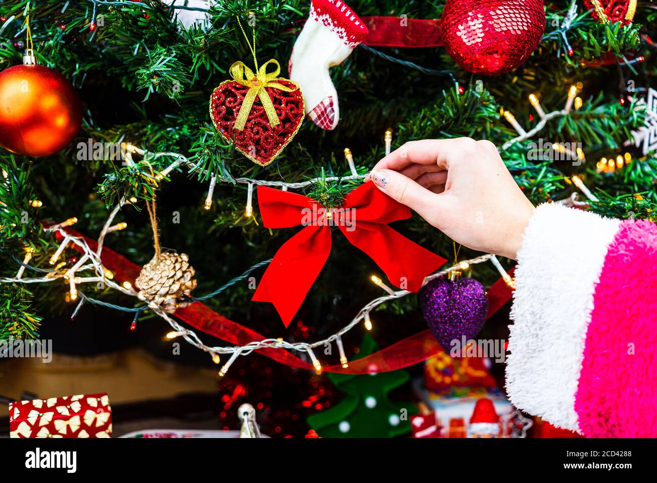 Decorating Christmas tree, hand putting Christmas decorations on fir ...