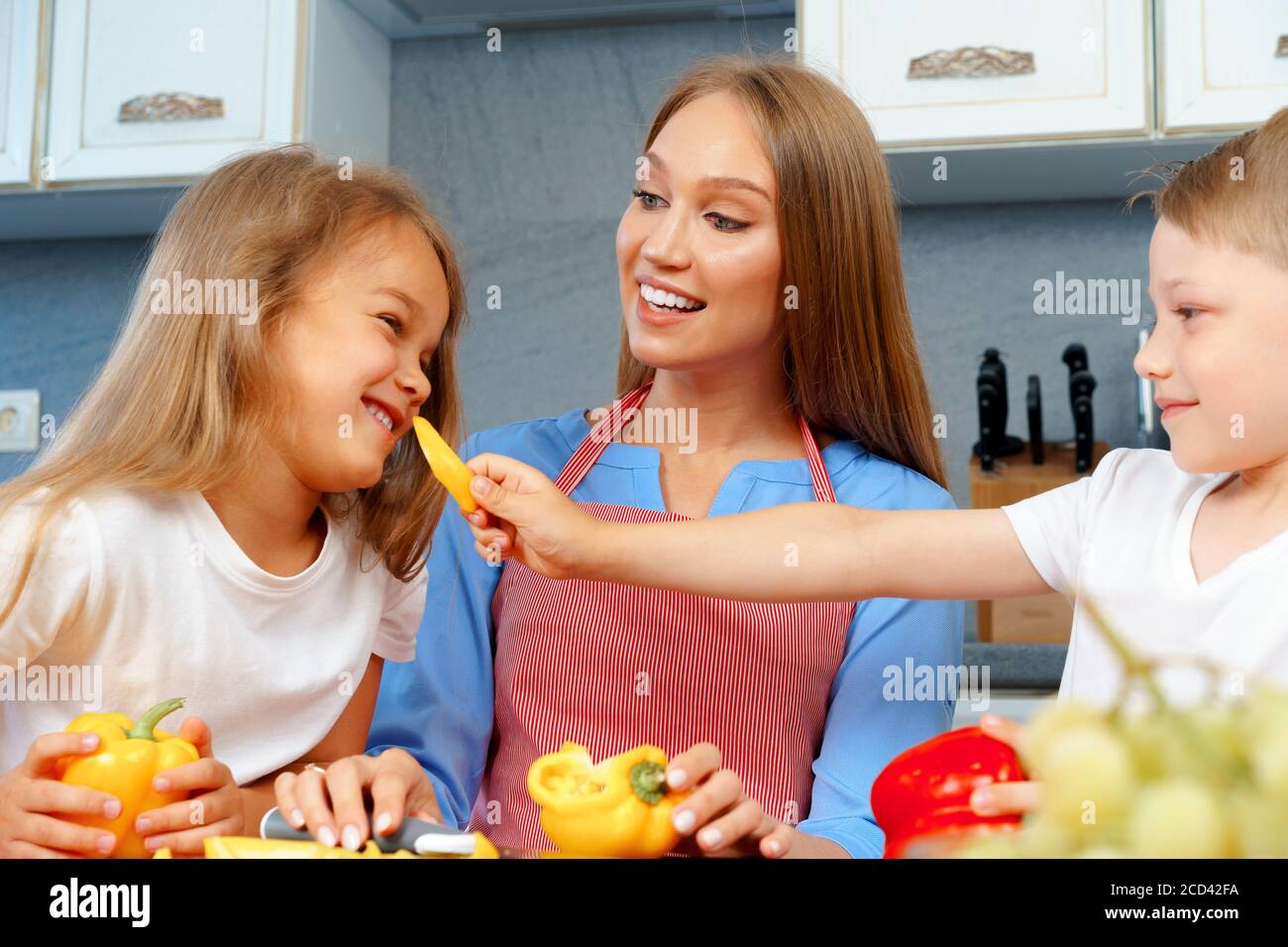 Mother cooking with her children in kitchen Stock Photo - Alamy
