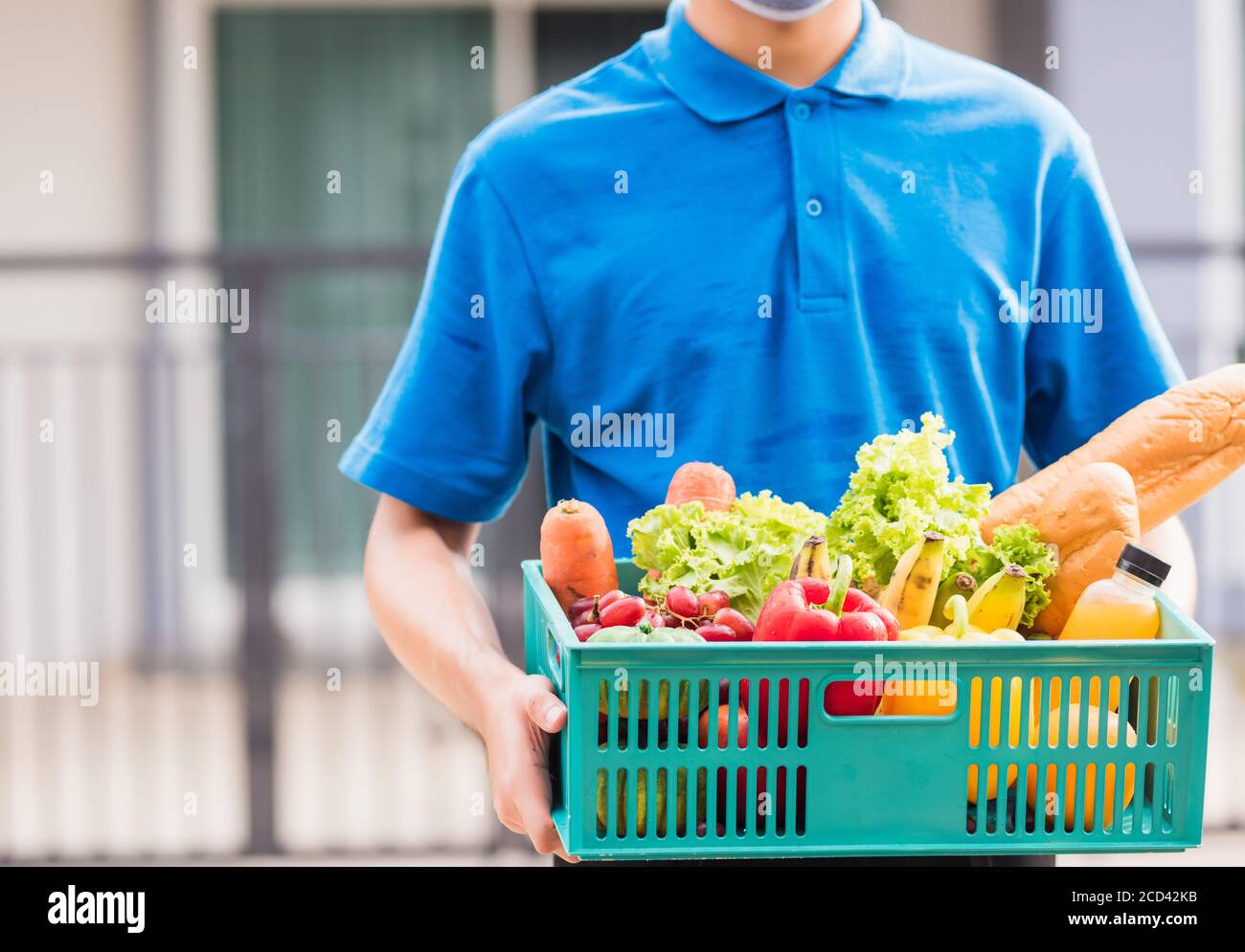 Asian grocery store delivery man wearing blue uniform and face mask ...