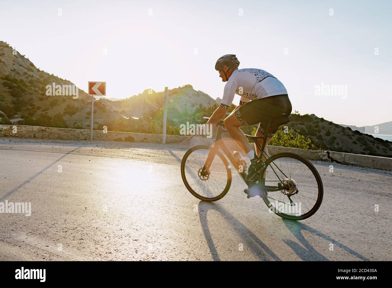 Cycling sport athlete man riding on coastal road Stock Photo - Alamy