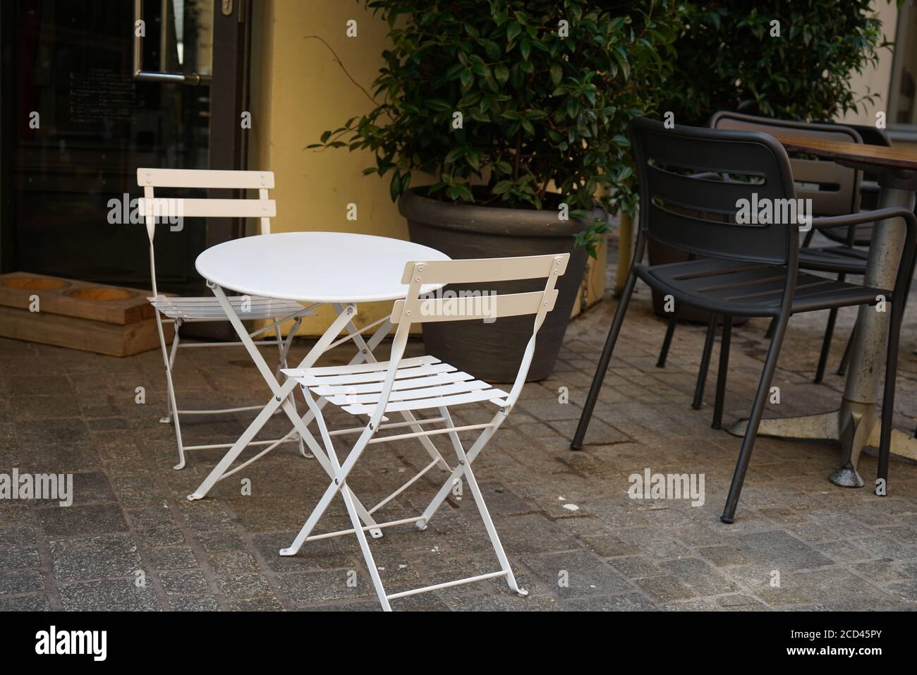 Outdoor cafe with straw chairs around the tables Stock Photo - Alamy