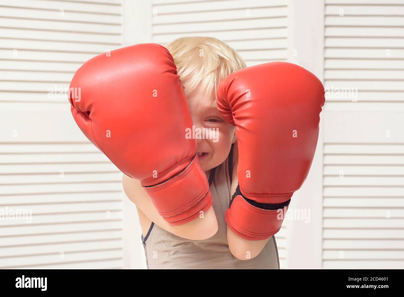 Blond boy is protected in two boxing gloves. Portrait Stock Photo - Alamy