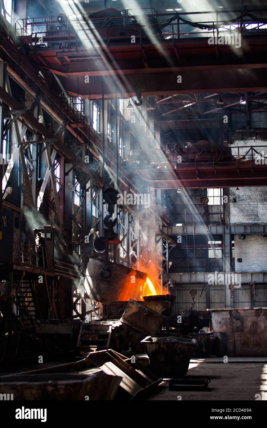 Metallurgy factory workshop. Melting of metal in progress. Red fire and ...