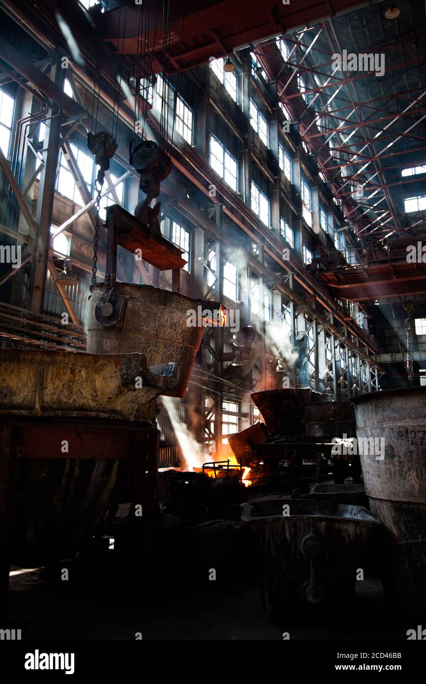 Metallurgy factory workshop. Melting of metal in progress. Red fire and ...
