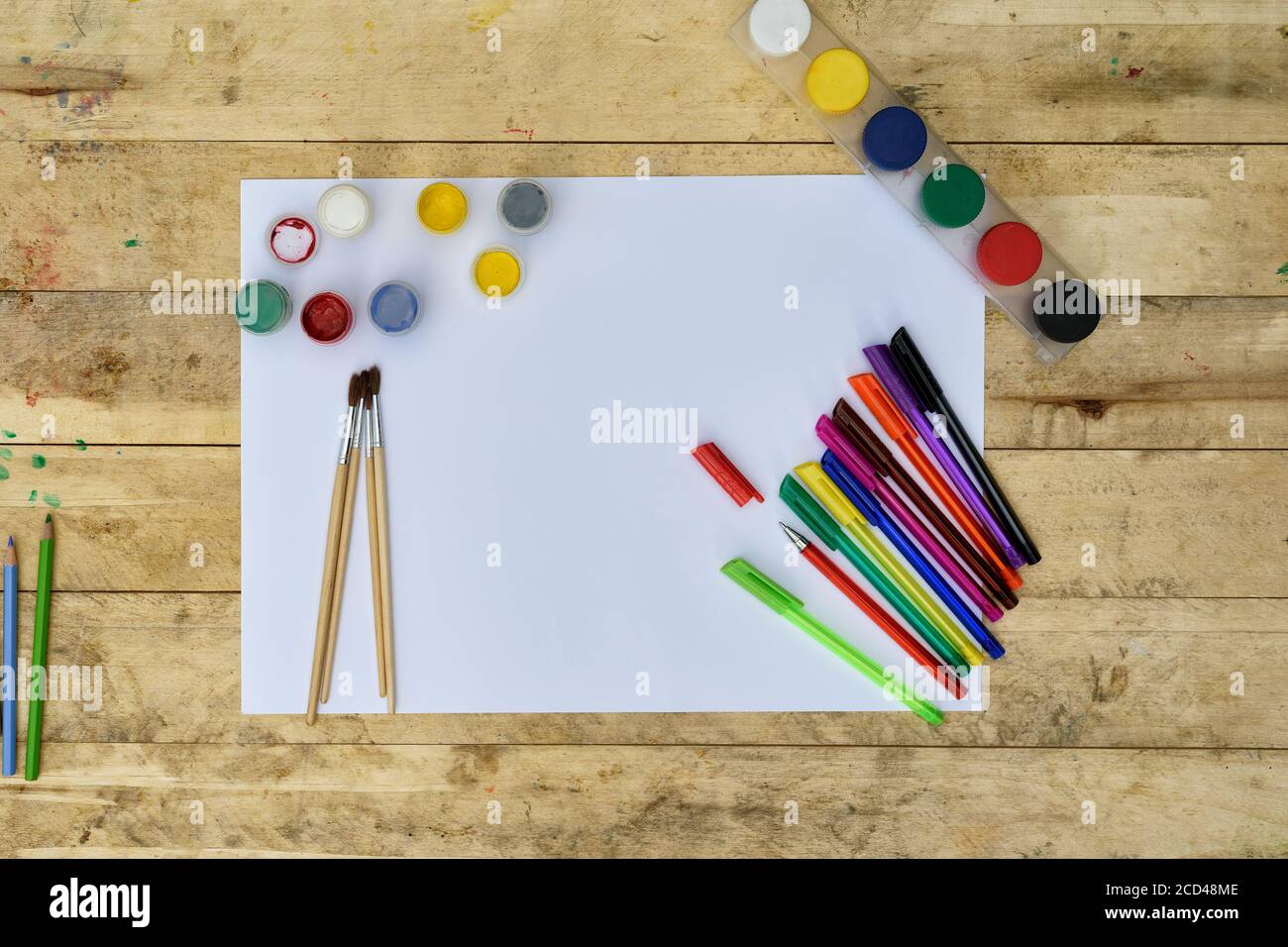 Art concept. Blank sheet of paper, paint, brushes and colored pens ...