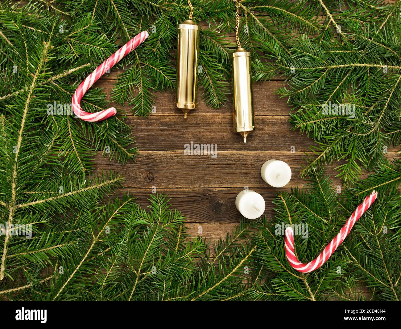 Wooden background. Fir branches, candy, candles and dumbbells from the ...