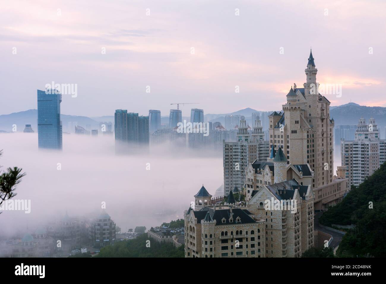 An aerial view of buildings, bridges and the Xinghai Bay covered by ...