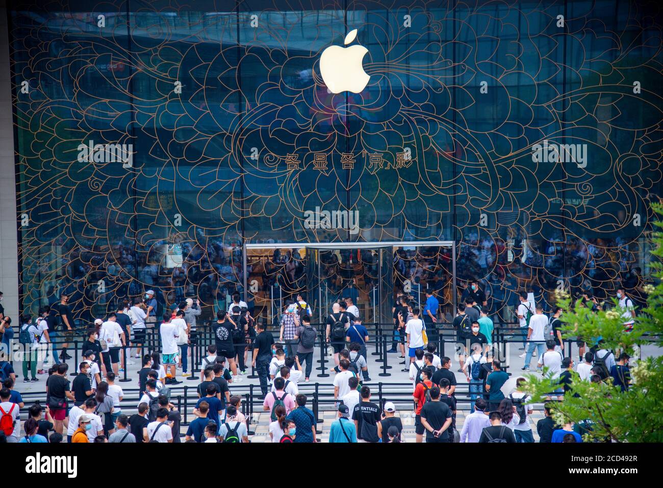 People line up to get inside the newly-opened Apple Store at Sanlitun ...