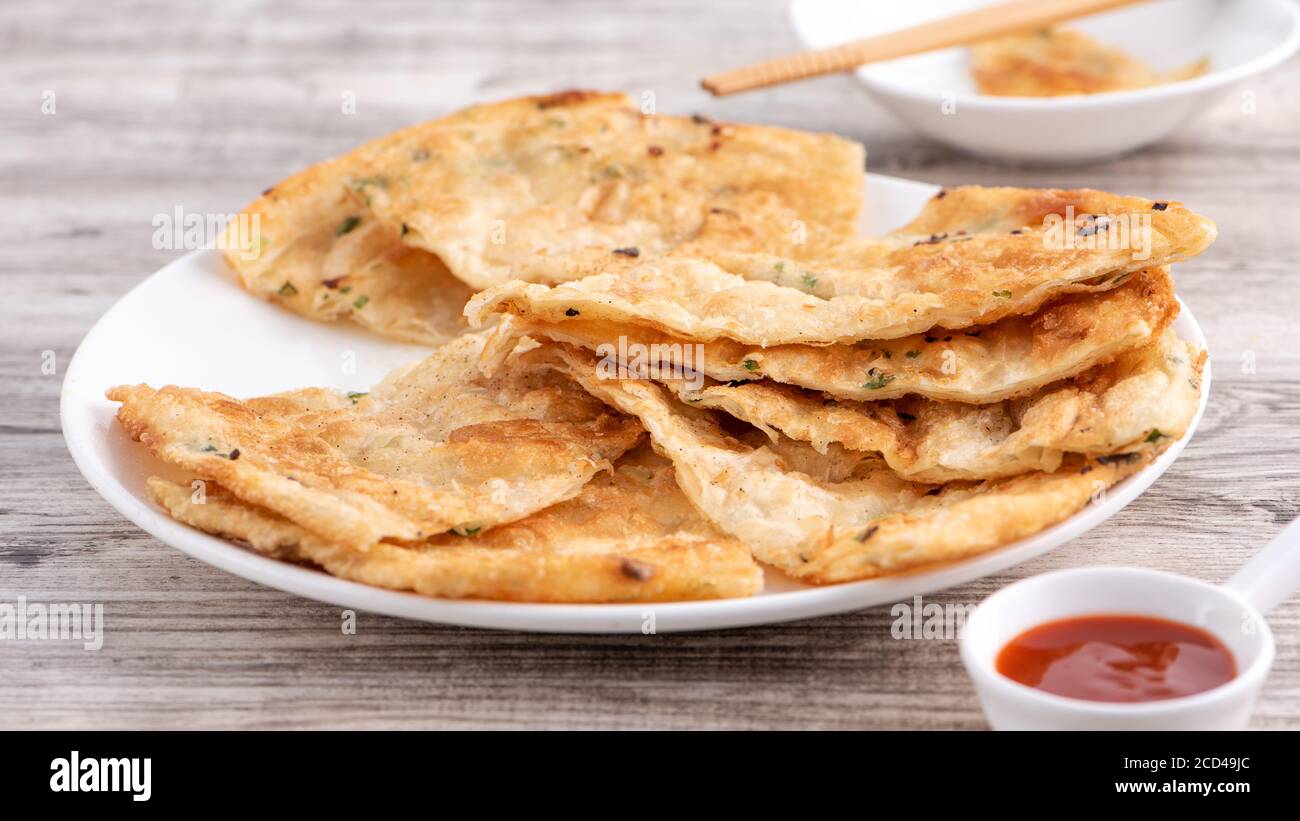 Taiwanese food - delicious flaky scallion pie pancakes on bright wooden ...