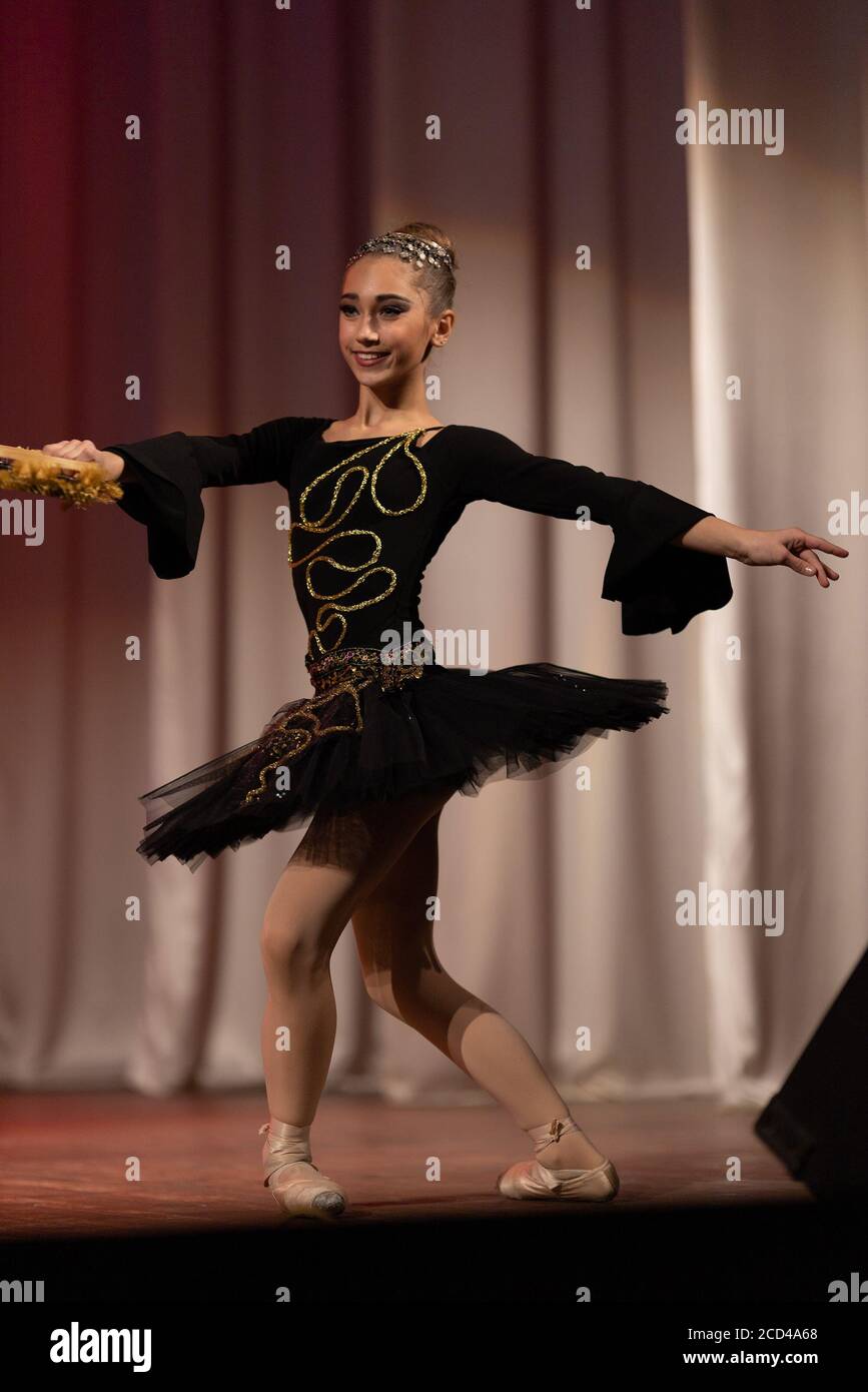 Young girl ballerina in a black tutu dress dancing performance on stage ...