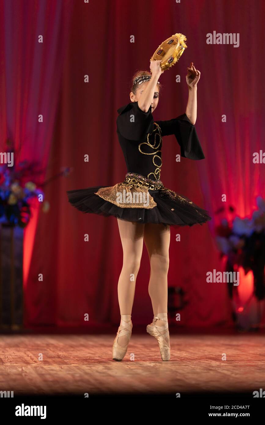 Young girl ballerina in a black tutu dress dancing performance on stage ...