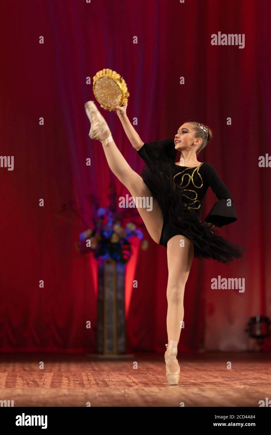 Young girl ballerina in a black tutu dress dancing performance on stage ...