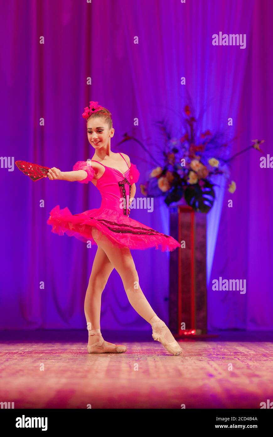 Young girl ballerina in a pink tutu performs with a performance on ...