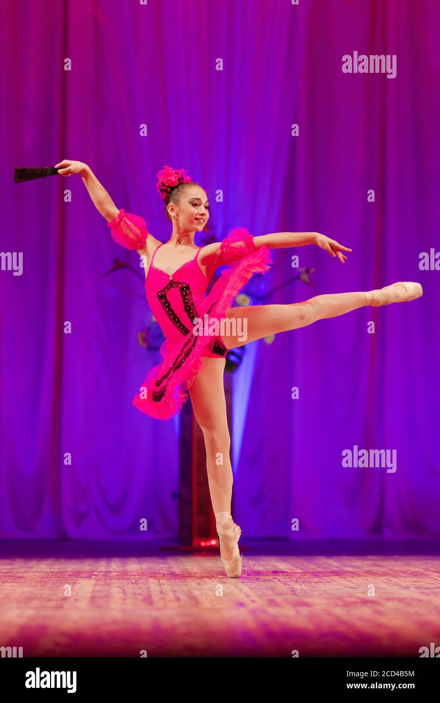 Young girl ballerina in a pink tutu performs with a performance on ...