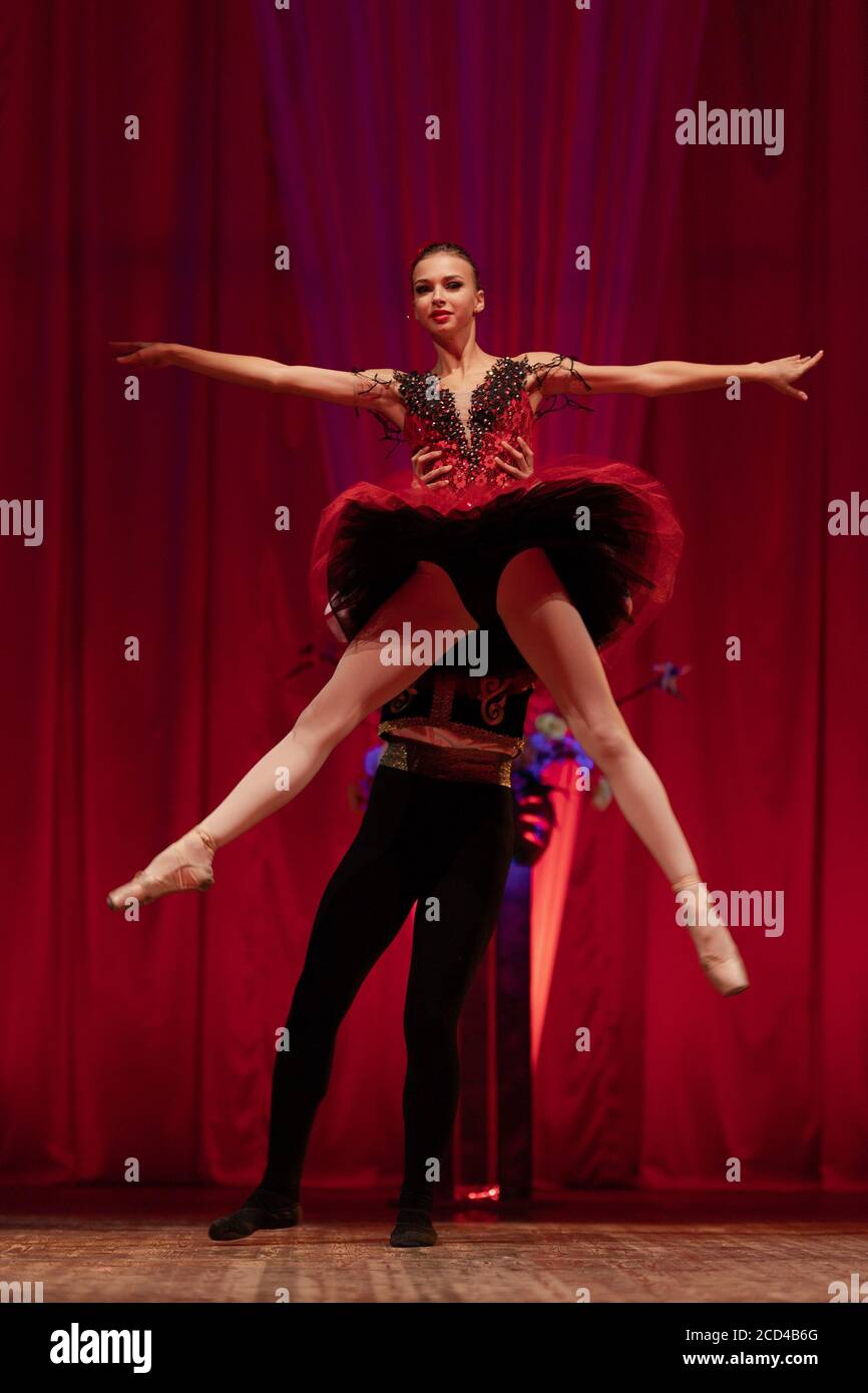 Young girl ballerina in a pink tutu performs with a performance on ...
