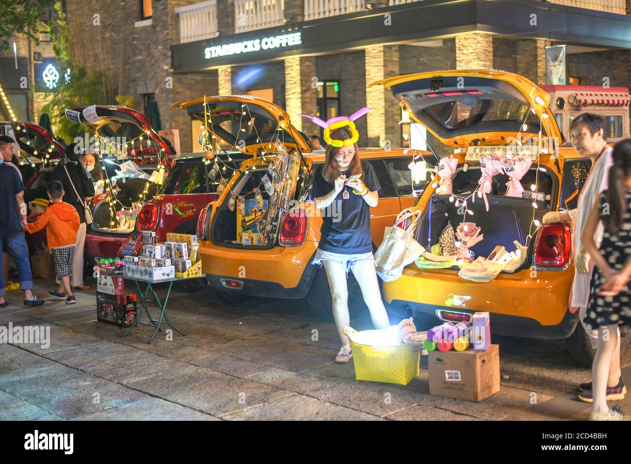 An array of car park and opens their trunk, where various products are ...
