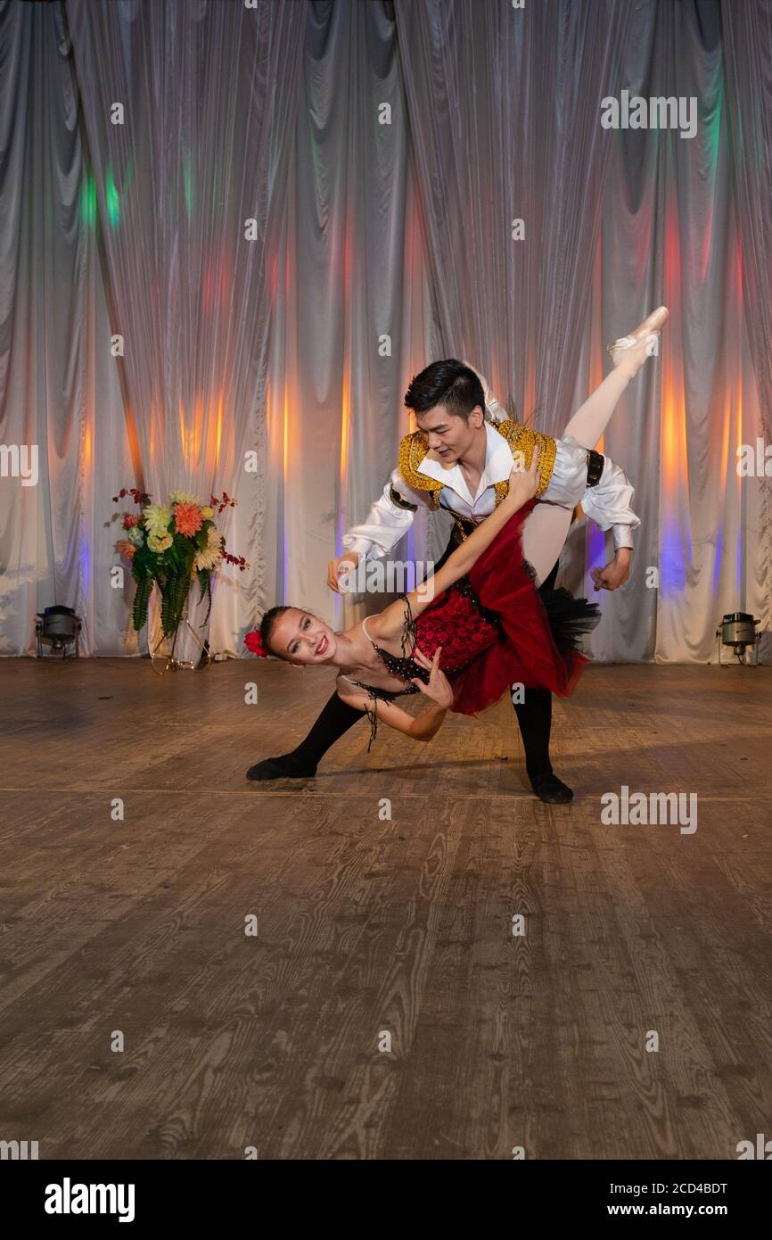 Duet young girl ballerina and a young man dancing ballet performance on ...