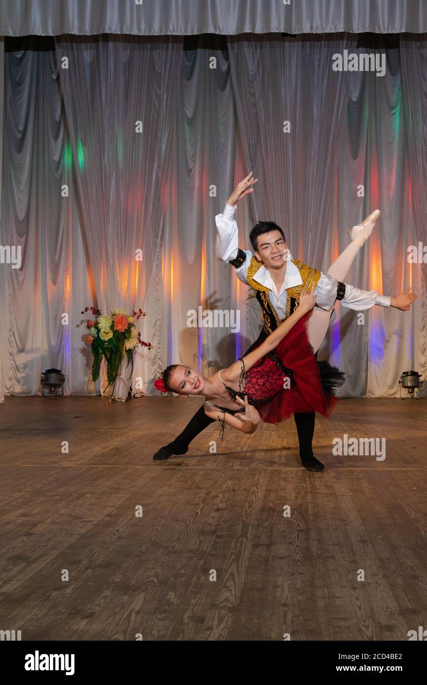Duet young girl ballerina and a young man dancing ballet performance on ...