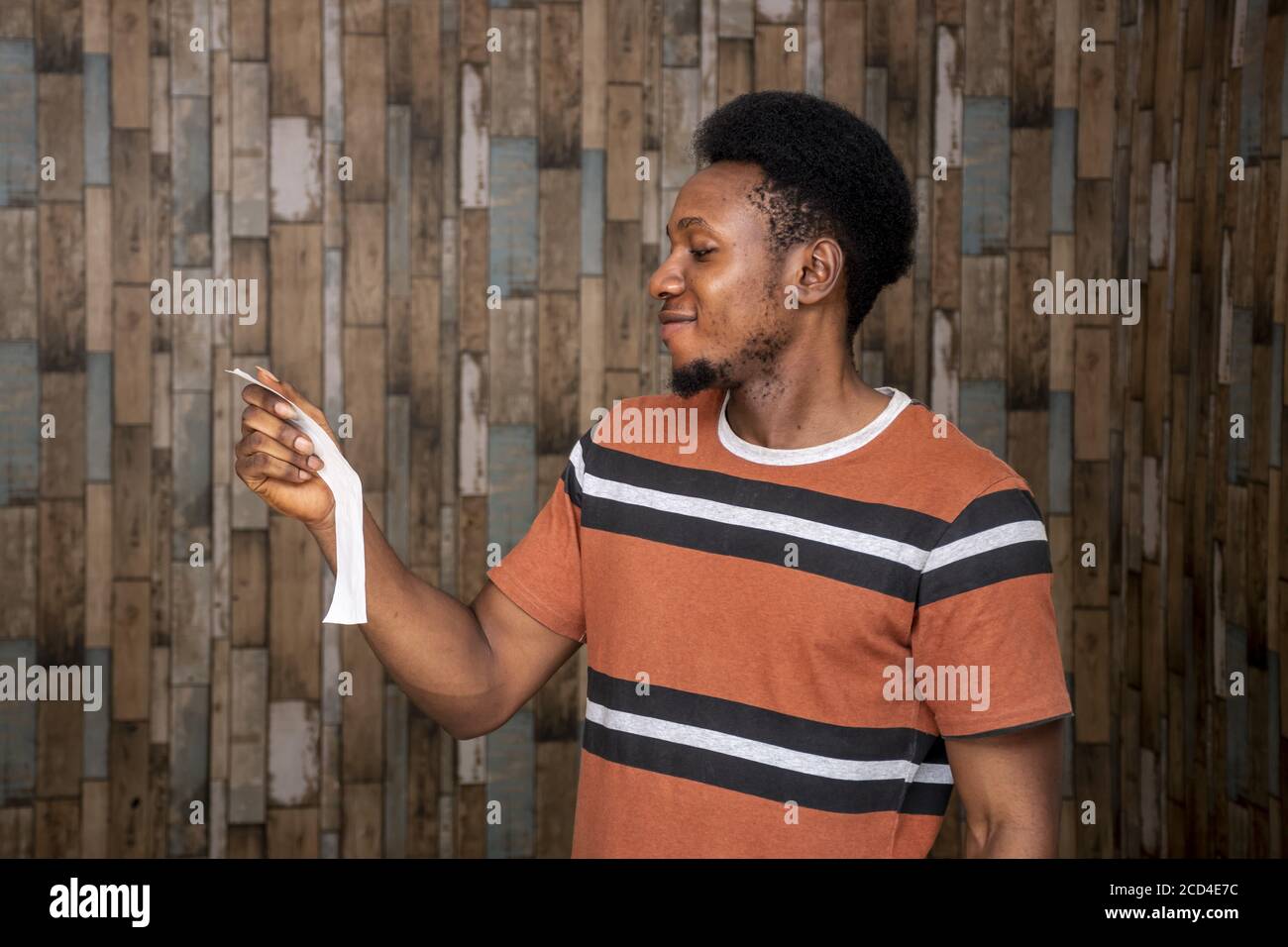 Young African male feeling unsure from what he read on the paper slip ...